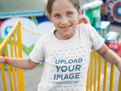 Placeit - Smiling Little Girl Wearing a T-Shirt Mockup While Outdoors