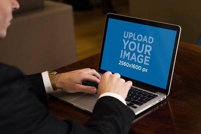 Placeit - Mockup of a Man Using a MacBook at Work