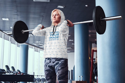 Placeit - Heather Hoodie Mockup of a Fit Woman Lifting Weights at the Gym